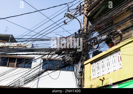 Intertwined electric wires in front of buildings which is the first ...