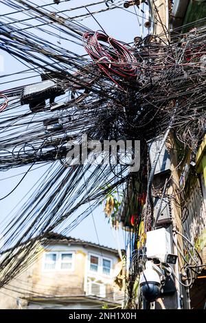 Intertwined electric wires in front of buildings which is the first ...