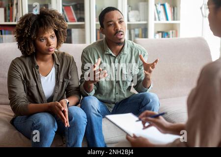 Upset young man with his wife visiting psychologist in office Stock ...