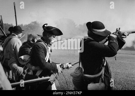 Colonial soldiers in a cloud of smoke fire their muskets at Red Coats ...