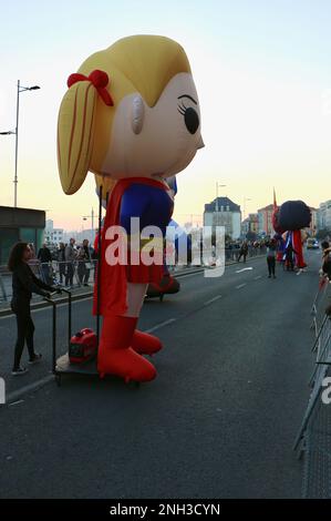 Evening carnival parade with an inflated Supergirl figure in the ...