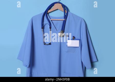 Doctor shirt with stethoscope, badge and pen hanging on light grey ...