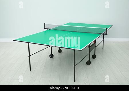 One green ping pong table with net indoors Stock Photo - Alamy
