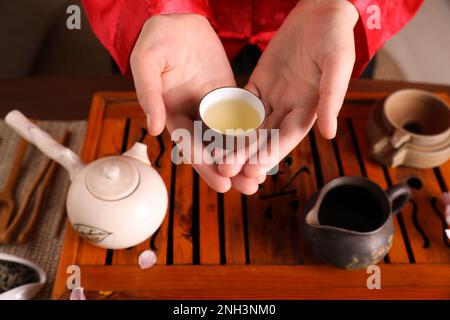 Master offering cup of freshly brewed tea during traditional ceremony ...