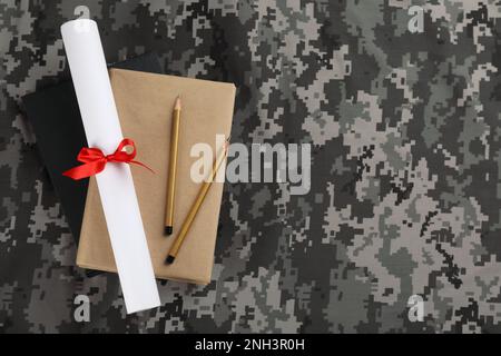 Books and diploma on camouflage background, top view with space for ...