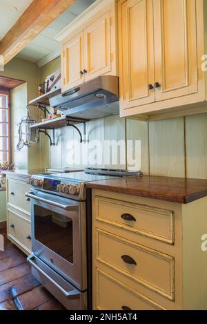 Antique white painted cabinets and stained wooden countertop in kitchen ...