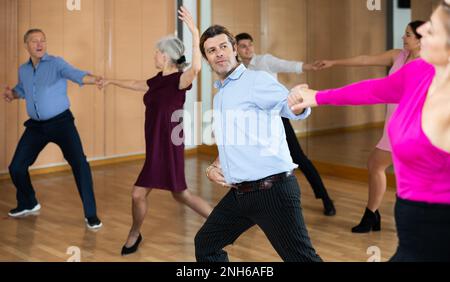 Middle-aged pair practicing ballroom dance in dance studio Stock Photo ...