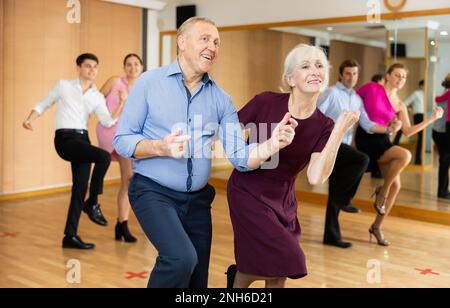 Aged couple dancing jive during group training Stock Photo - Alamy