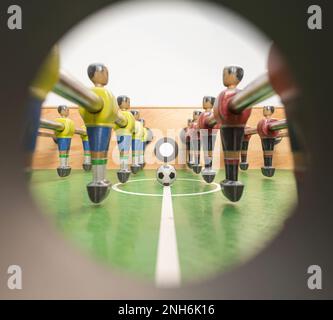 A vintage wooden foosball table with detailed metal player figurines in ...