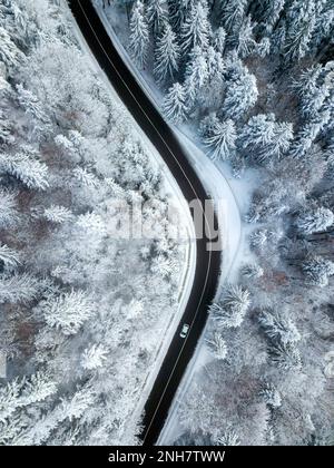 Curvy windy road in snow covered forest, top down aerial view Stock ...