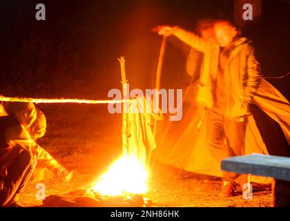 Abstract photo of silhouettes of people around a night fire Stock Photo ...