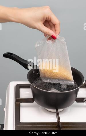 Man cooking rice with gas burner while camping Stock Photo - Alamy