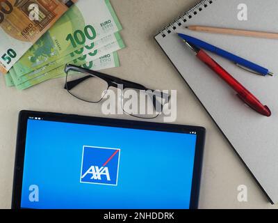 In this photo illustration AXA Group logo seen displayed on a tablet ...