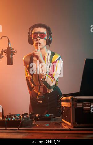 Musical performer doing hush mute sign, playing guitar at microphone ...