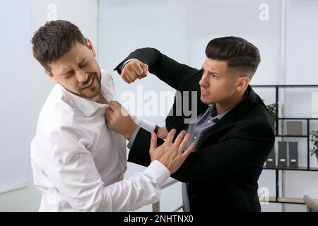 Emotional colleagues fighting in office. Workplace conflict Stock Photo ...