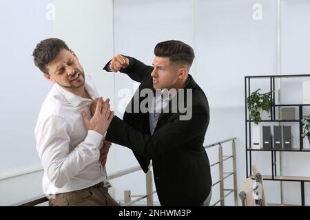 Emotional colleagues fighting in office. Workplace conflict Stock Photo ...