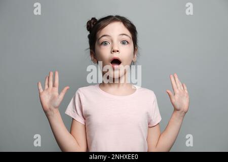 Little girl feeling fear on grey background Stock Photo - Alamy
