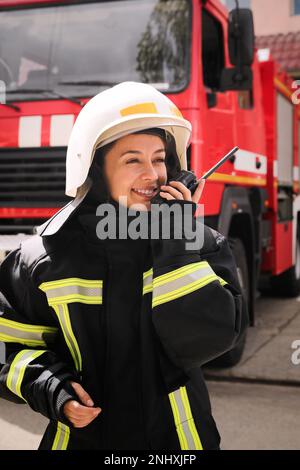 Firefighter in uniform using portable radio set near fire truck Stock ...