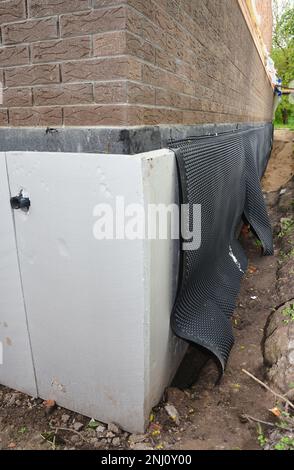 External house basement foundation wall insulation with rigid foam board before waterproofing ...