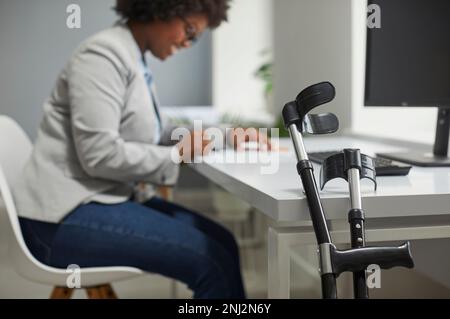Injured female employee working in the office Stock Photo - Alamy