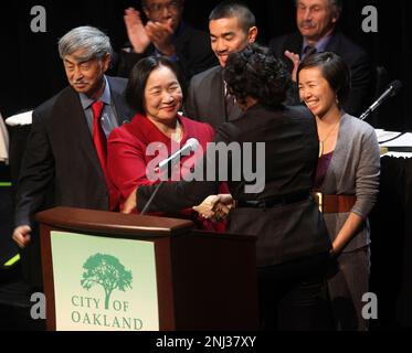 Oakland's new mayor Jean Quan (in red) is applauded after the ...