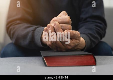 Please, Lord. Nervous worried aged Caucasian man praying on couch at ...