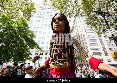 The 12-foot puppet known as "Little Amal" walks through Times Square as ...