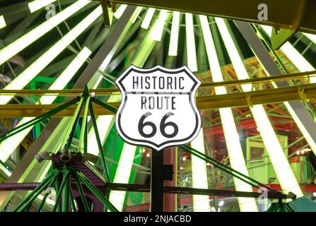 A picture of the Route 66 sign at night, with the Pacific Wheel in the ...