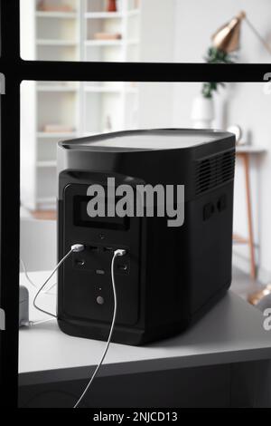 Portable power station charging devices on floor in living room Stock ...
