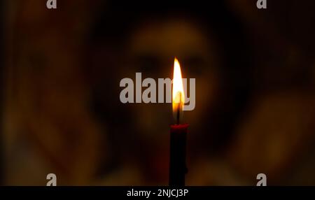 burning candle illuminates the icon of Jesus Christ Stock Photo - Alamy