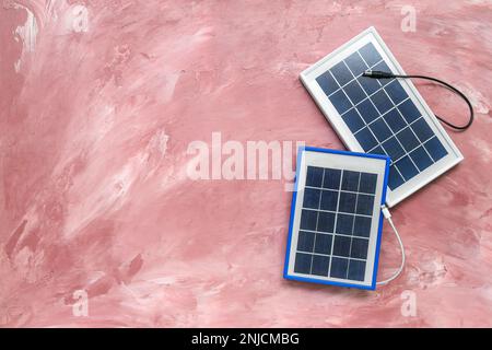 Portable solar panels with cables on pink grunge background Stock Photo ...