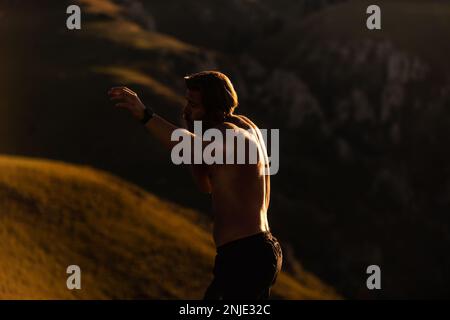 Man boxing with shadow exercising at sunset outdoor. Port victory ...