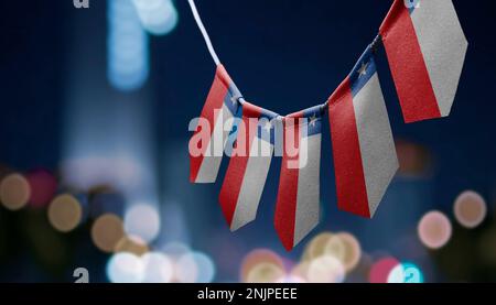 A garland of Chile national flags on an abstract blurred background ...