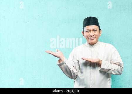 Asian Muslim man with open palm hand showing something isolated over ...