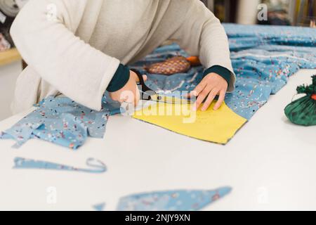 Female tailor cutting fabric working in workshop Stock Photo - Alamy