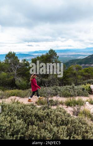 A hiker walking up a hill near the mountains on a beautiful day Stock ...