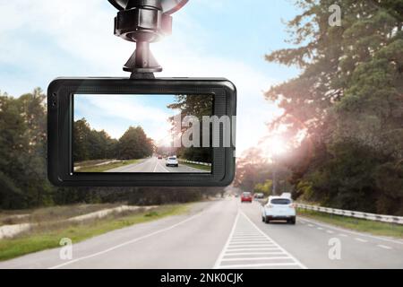 Modern dashboard camera mounted in car, view of road during driving ...