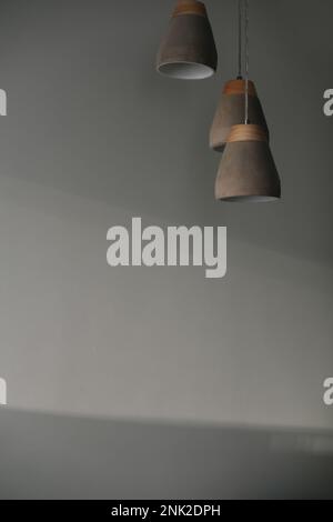 Fancy hanging lamps with wooden parts on the white wall background ...