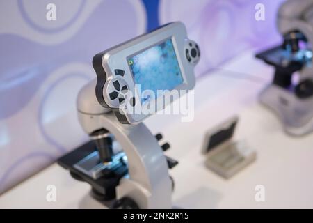 Microscopes with display and control buttons on white table - close up ...