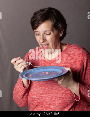 Older woman with an empty blue plate Stock Photo - Alamy