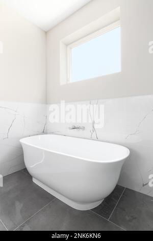 Faucet above dark marble sink in light bathroom on sunny day Stock ...