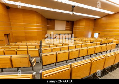 Interior of big conference hall full of gray folding chairs and wooden ...