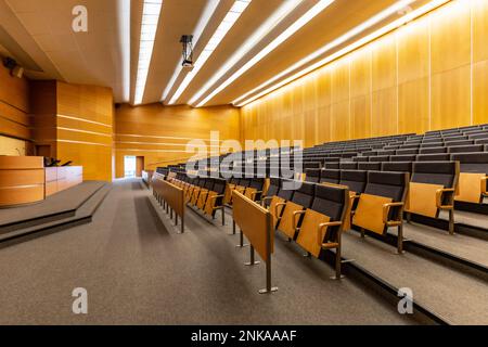 Interior of big conference hall full of gray folding chairs and wooden ...