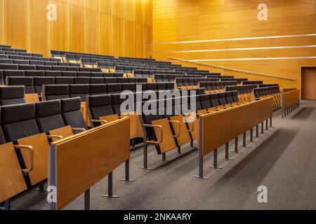 Interior of big conference hall full of gray folding chairs and wooden ...