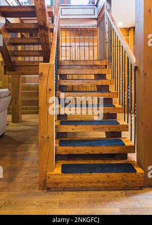 Wooden log stairs with black wrought iron railings and long cabinet ...