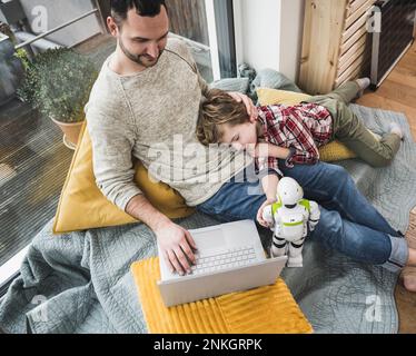 Father and son using napping on the couch Stock Photo - Alamy