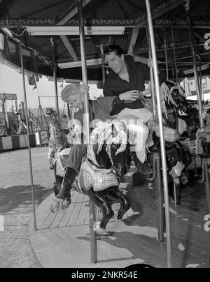 Barbara Stanwyck and Elvis Presley riding a motorcycle at the set of ...