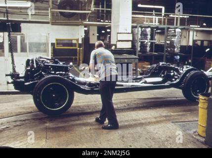 1970s America: On the Cadillac assembly line--attaching axle to frame ...