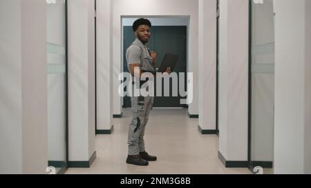 African-American security cameras installer in uniform stands in ...