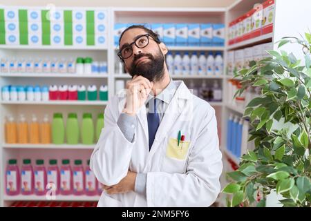 Hispanic man with beard working at pharmacy drugstore holding credit ...